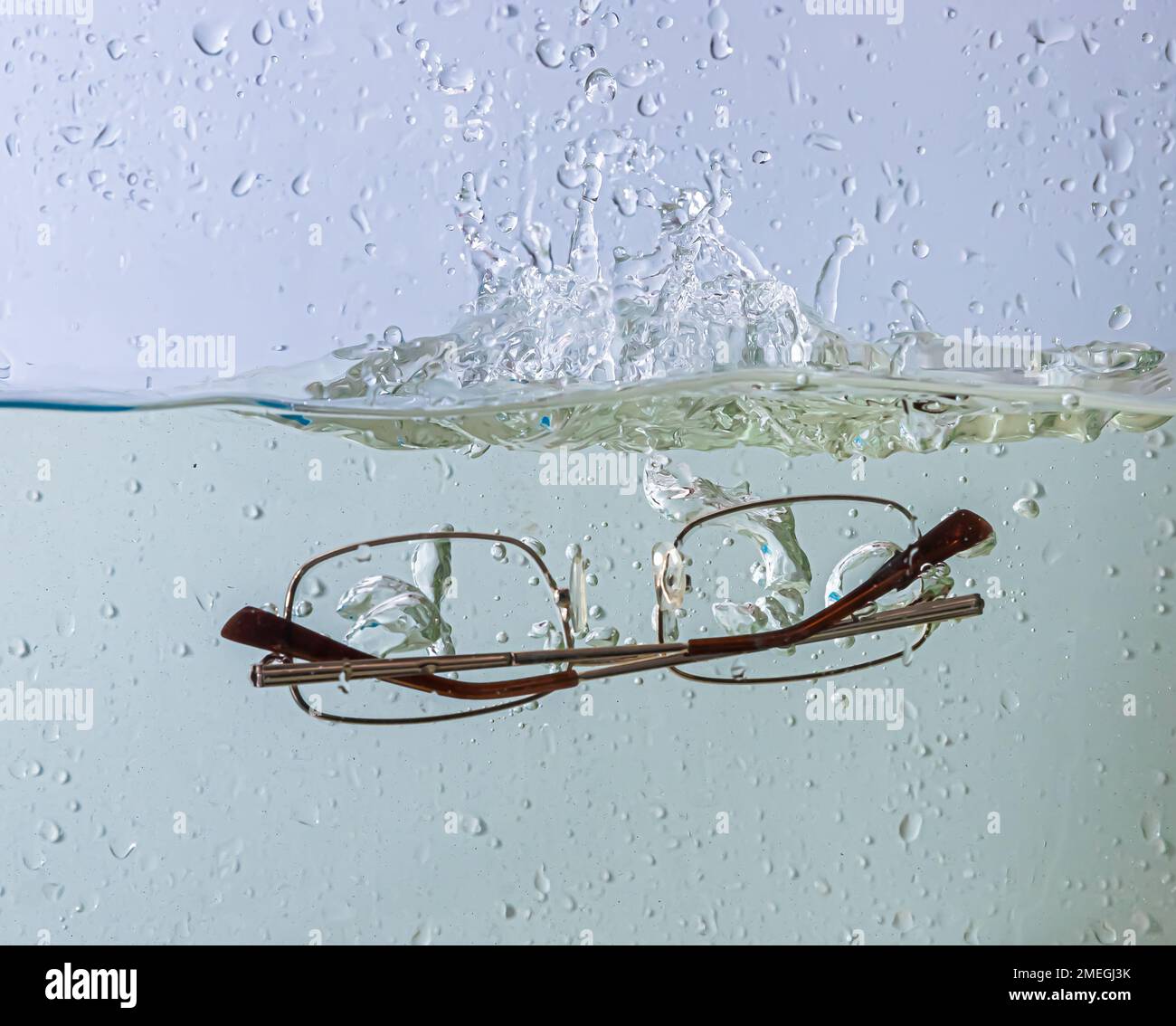 glasses fall into the water. sprays, drops and bubbles Stock Photo - Alamy