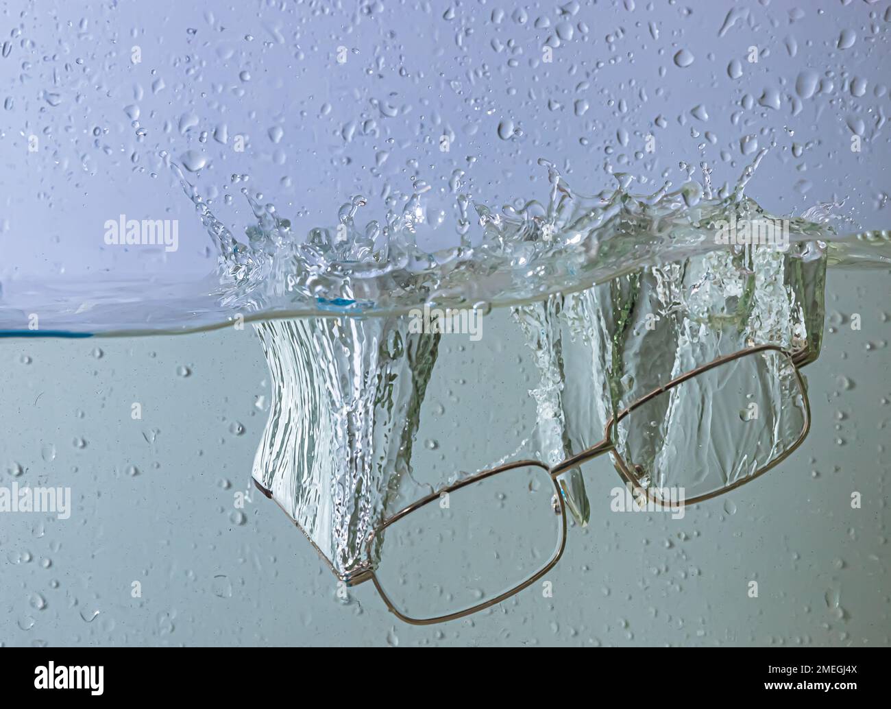 glasses fall into the water. sprays, drops and bubbles Stock Photo - Alamy