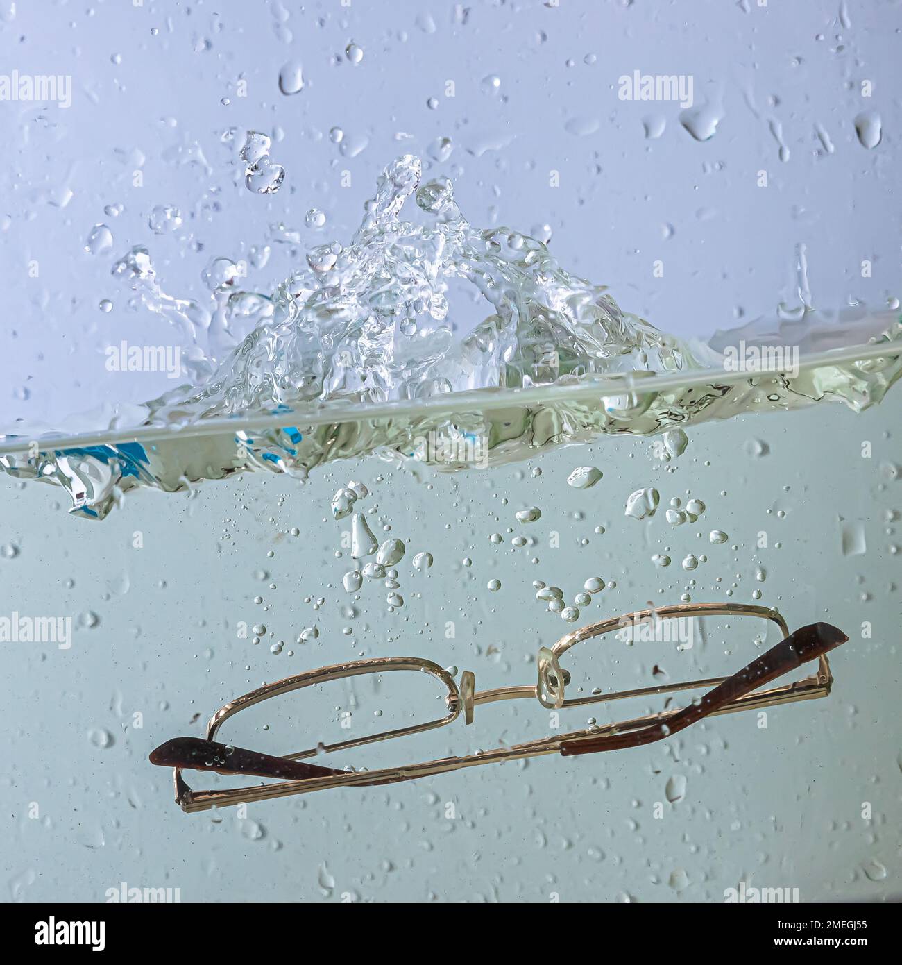 glasses fall into the water. sprays, drops and bubbles Stock Photo - Alamy
