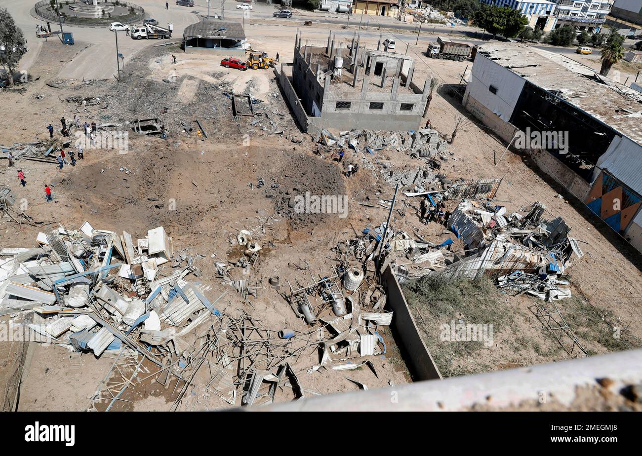 People gather near the rubble of an ice factory and mechanic garages ...