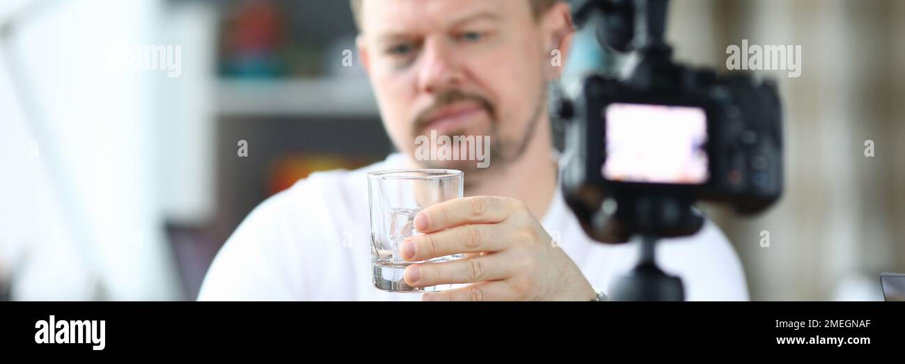 Exhausted man with black eye drinks alcohol in front of camera Stock ...