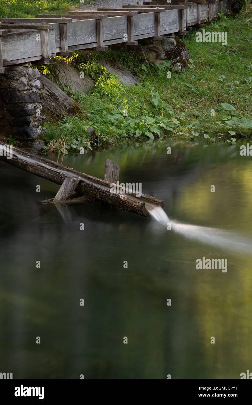 A small pond with a channel where water runs through Stock Photo - Alamy
