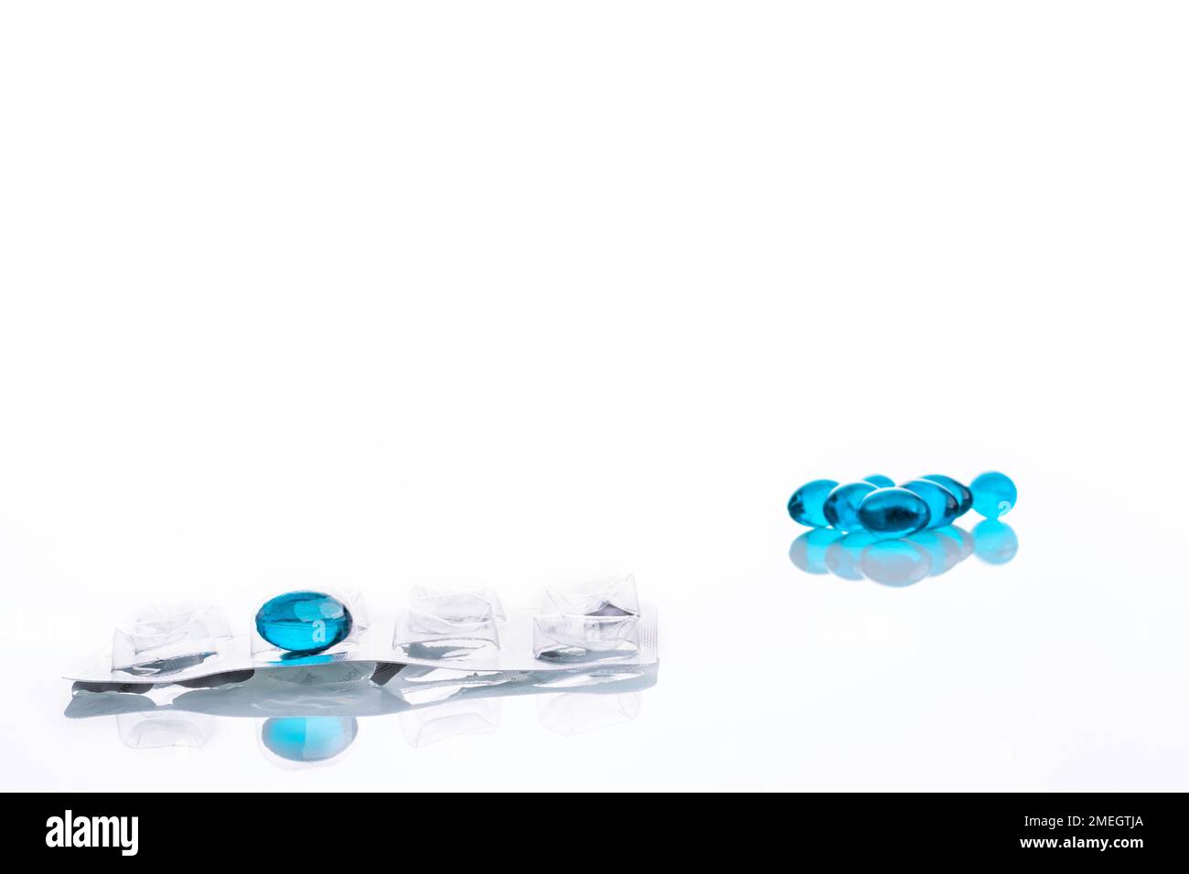 A close-up shot of blue vitamin capsules isolated in white background ...