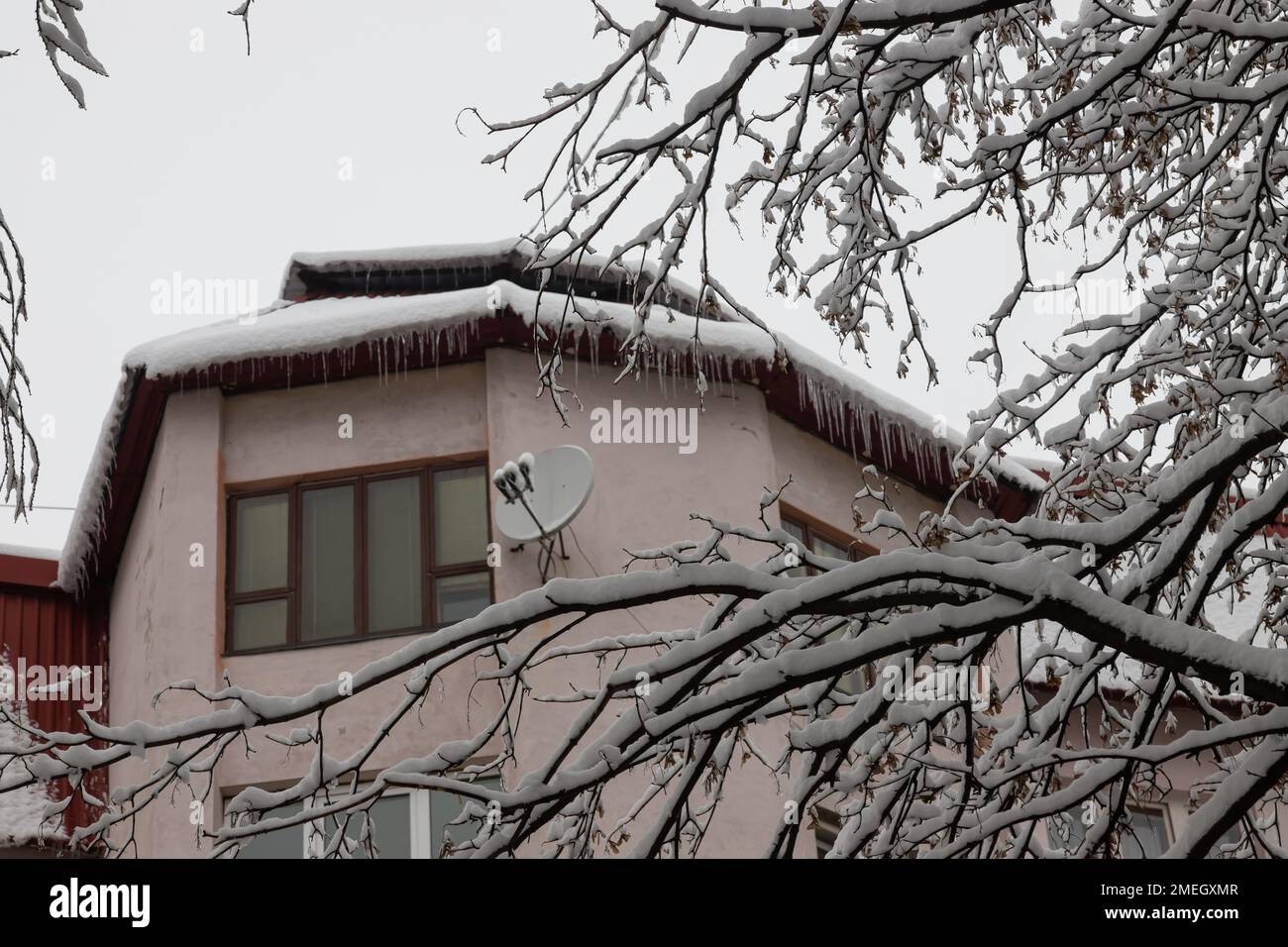 Facade of a residential building in the suburbs during a snowfall. The ...