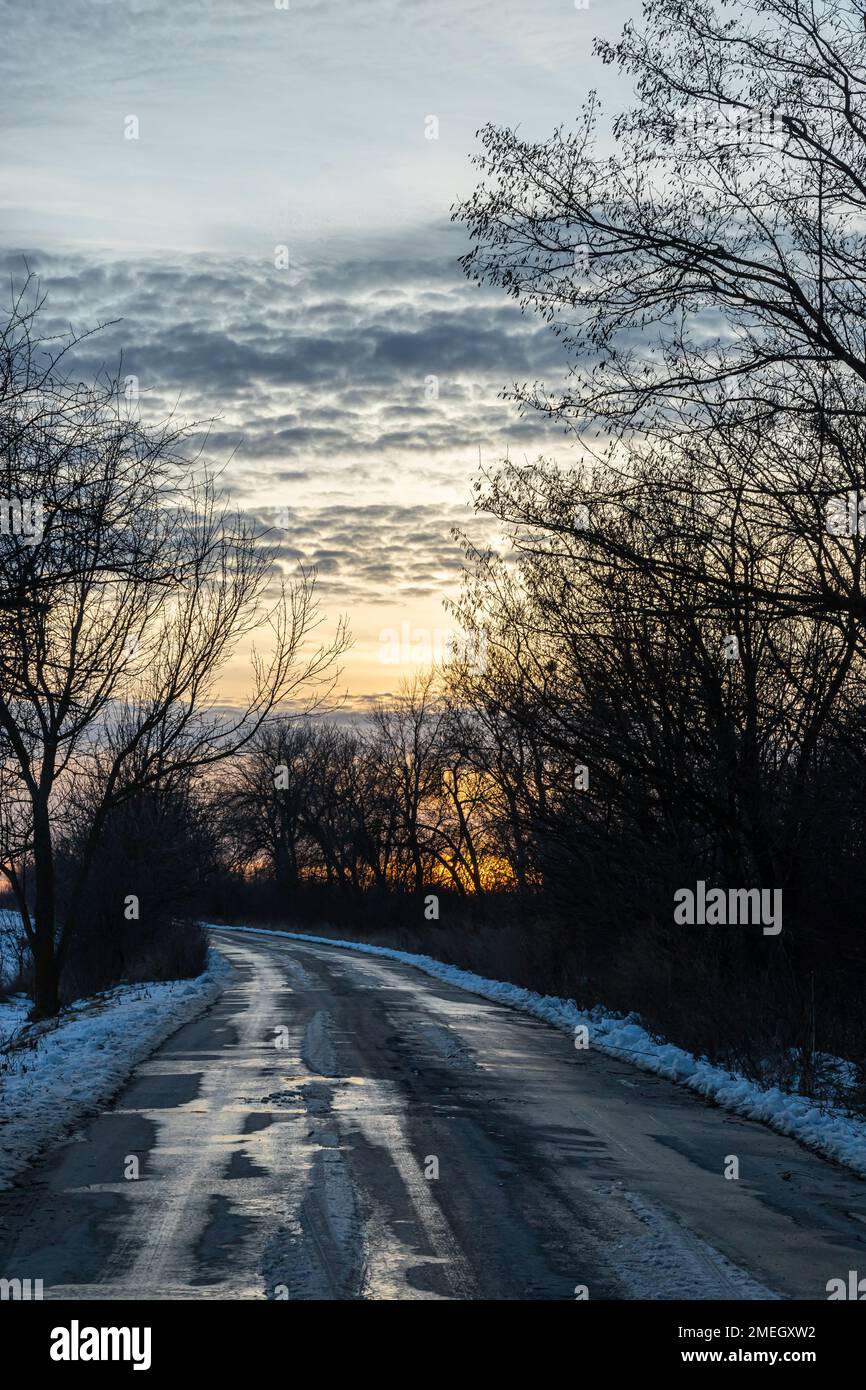 Winter road against the backdrop of a sunny sunset. Direction of ...