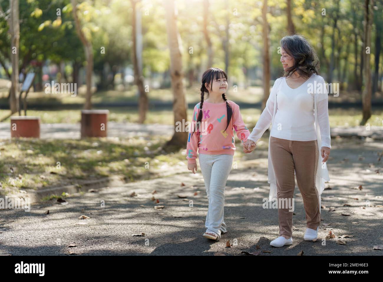 Asian Grandmother and Granddaughter walking together outdoor park ...