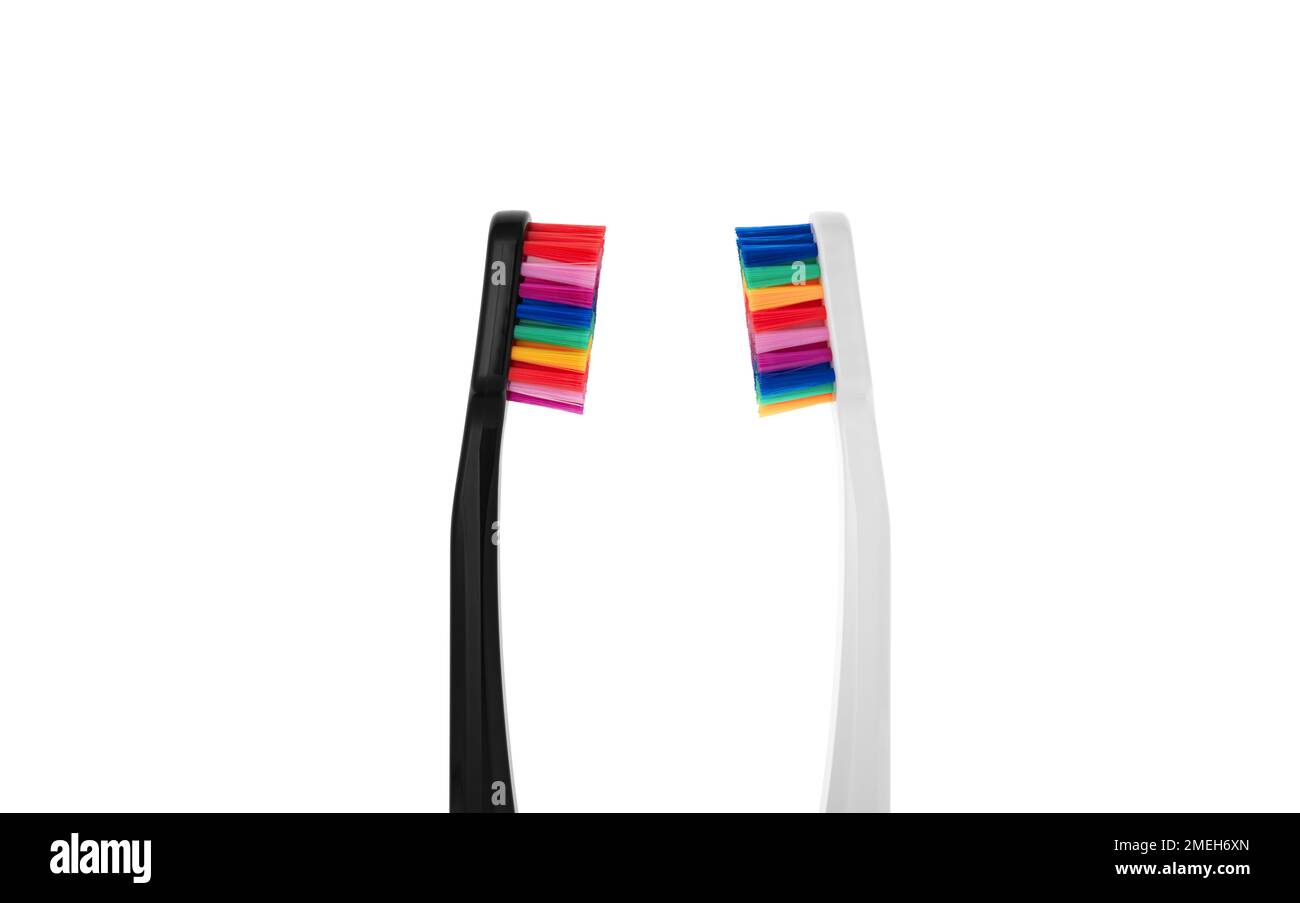 Black and White toothbrushs with multicolored bristles on white ...