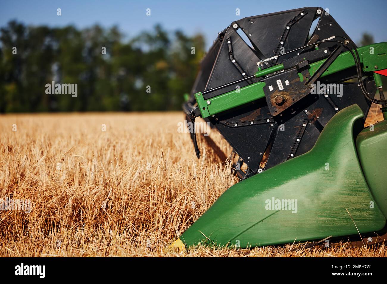Agricultural combine John Deere harvester in the field during harvest ...