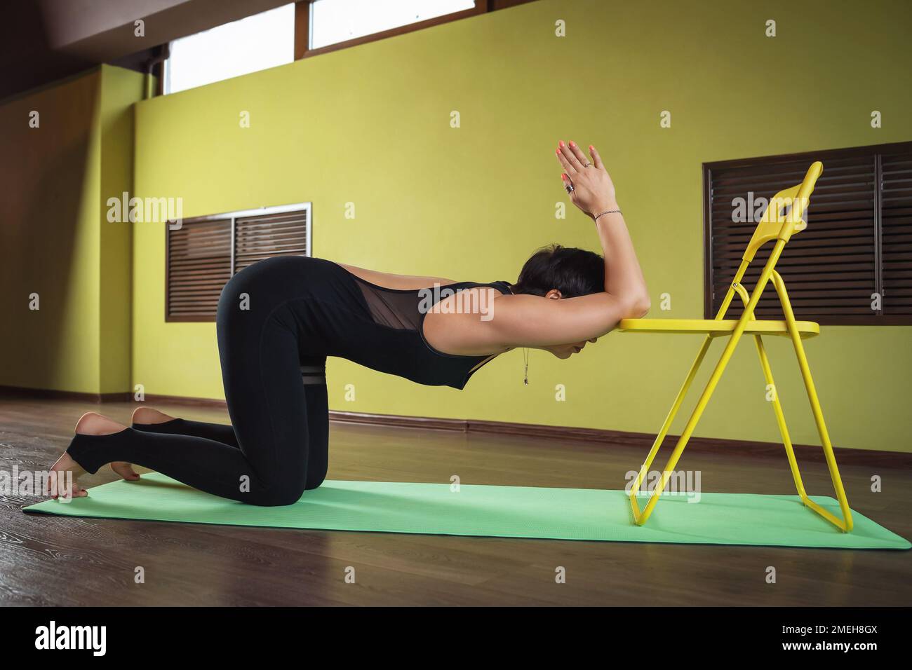 Attractive middle aged woman practicing yoga performs various exercises ...