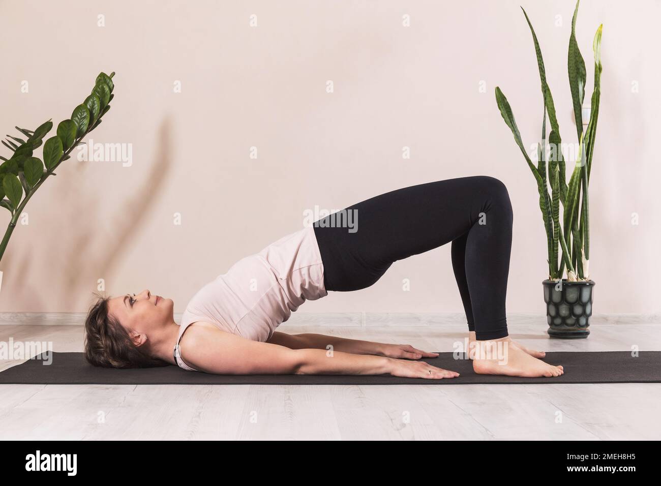 A woman leading a healthy lifestyle and practicing yoga, performs the ...