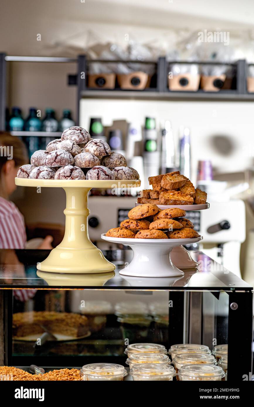 Young barista girl near a modern window enjoys a cup of coffee, looking ...