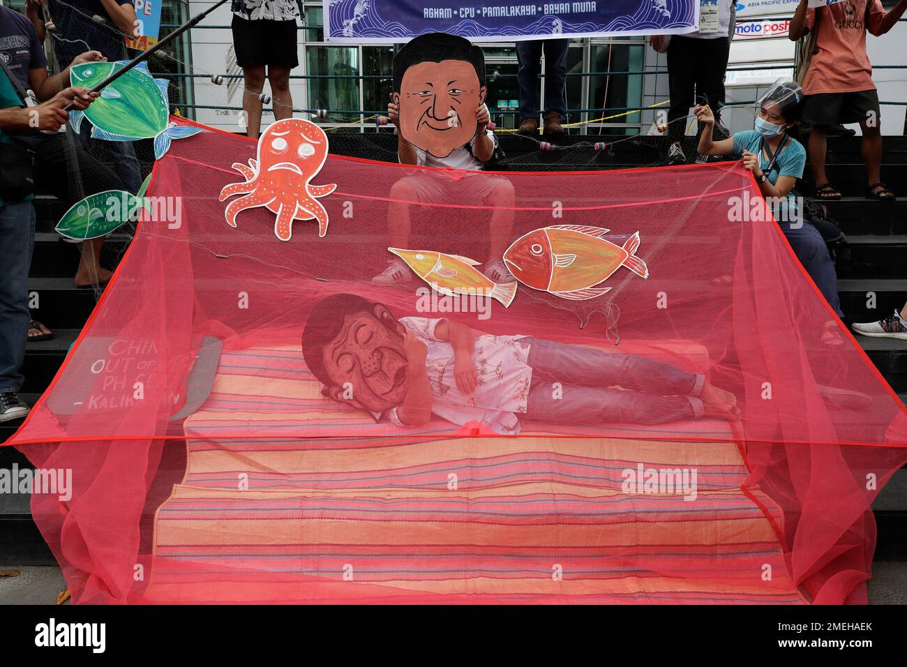A protester wearing a mask bearing a face of Philippine President ...