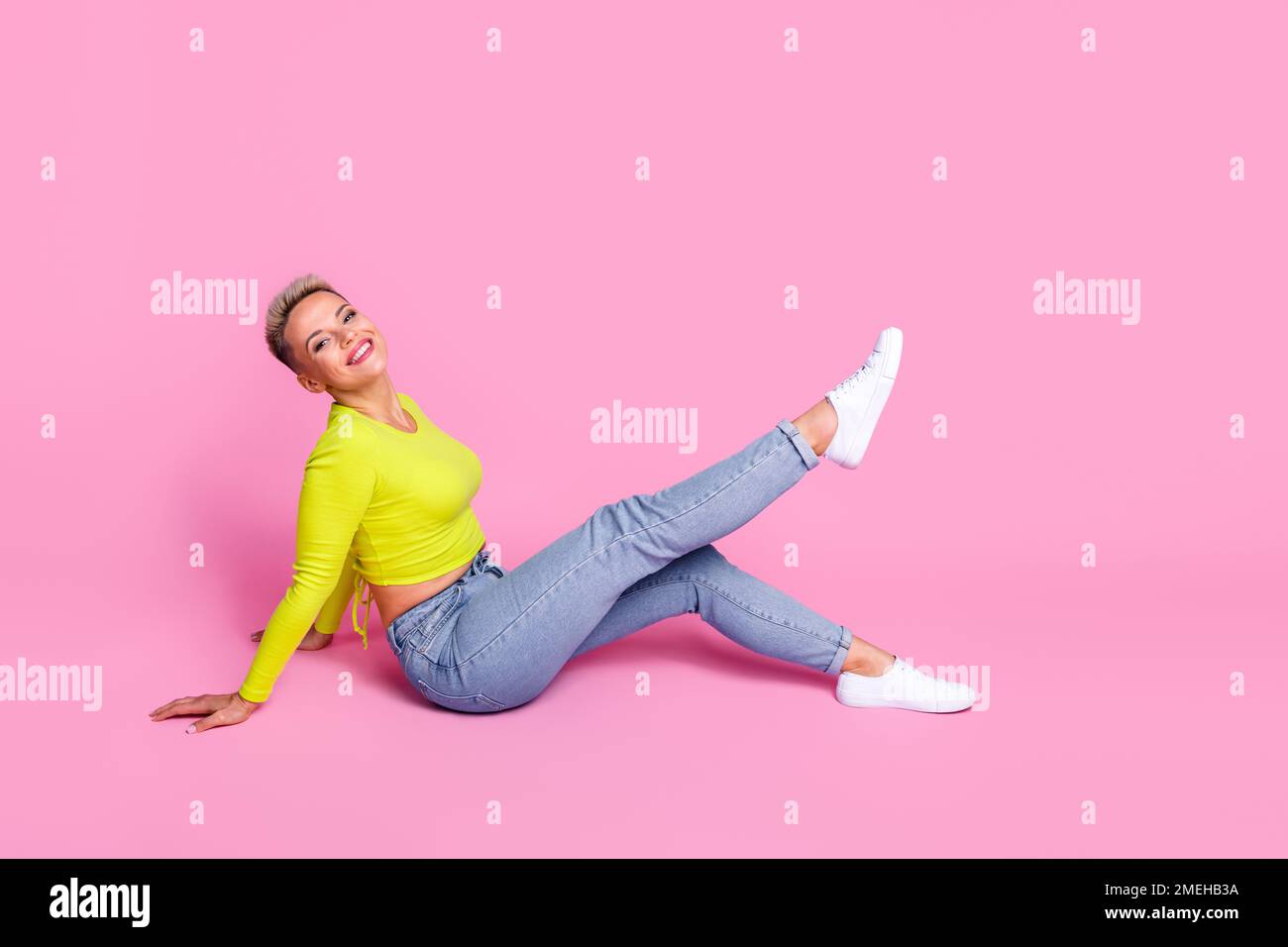 Full size profile portrait of cheerful lovely girl sit floor raise leg ...