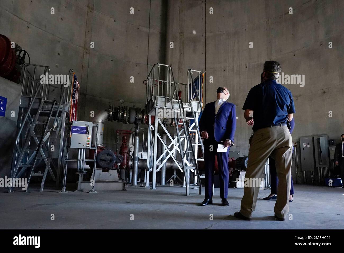 President Joe Biden looks up as he tours a water tower at the Sewerage ...