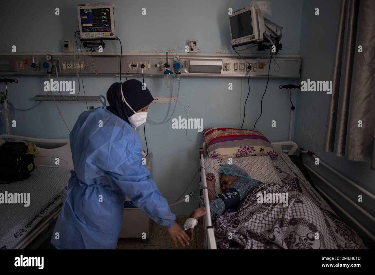 A Palestinian nurse checks on a COVID-19 patient inside the intensive ...
