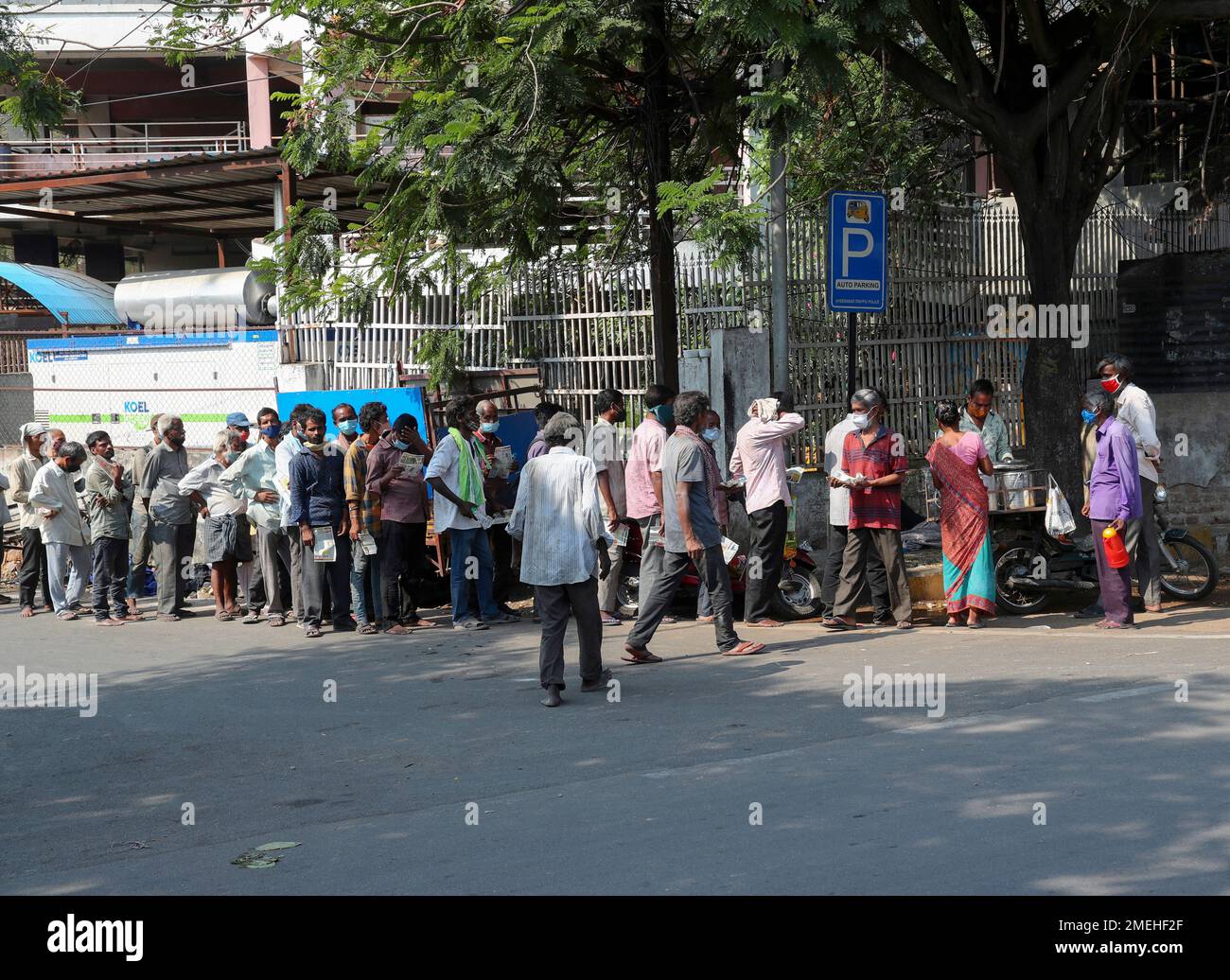 Homeless people queue up for free food being distributed by a charity ...