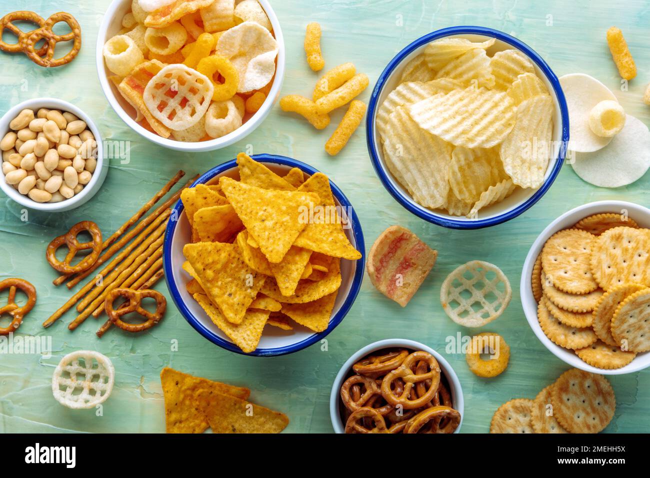 Salty snacks. Party food on a blue background. Potato and tortilla ...