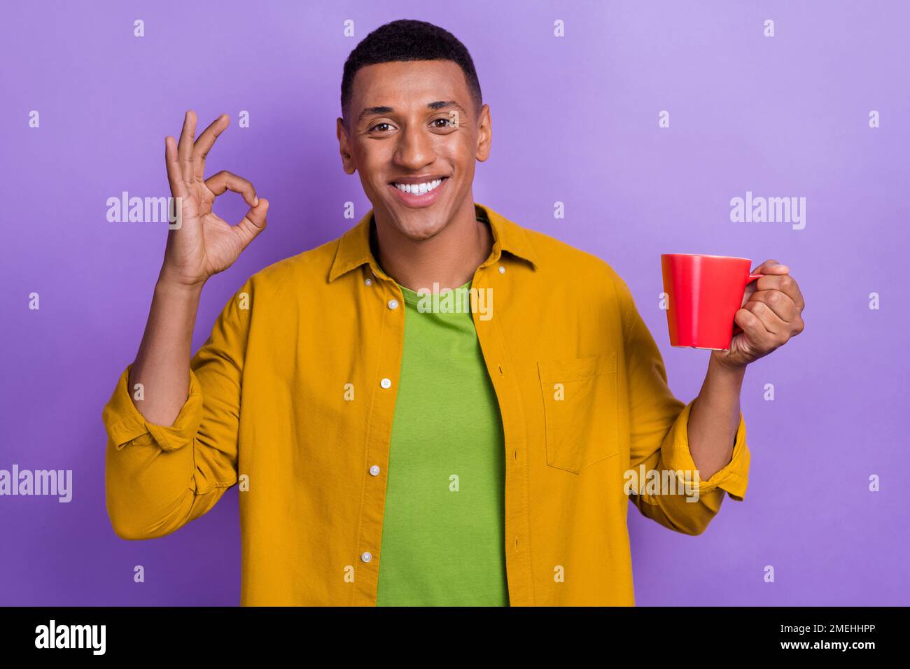 Portrait of positive satisfied handsome guy wear yellow clothes holding ...