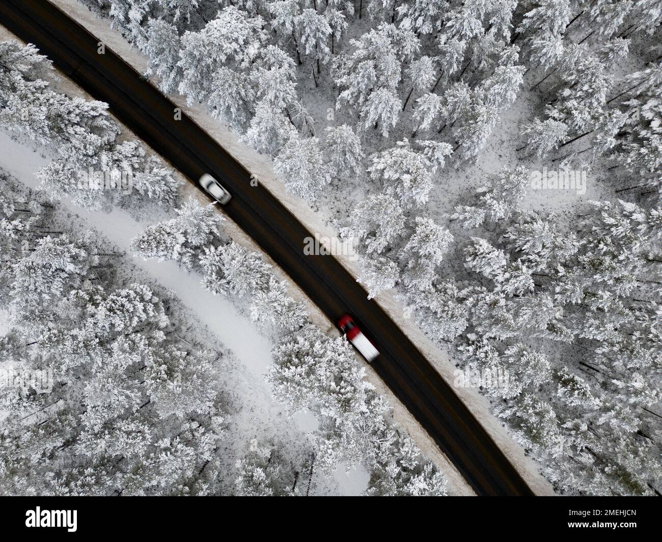 Aerial view of road in snow Rothiemurchus forest in Cairngorms national ...