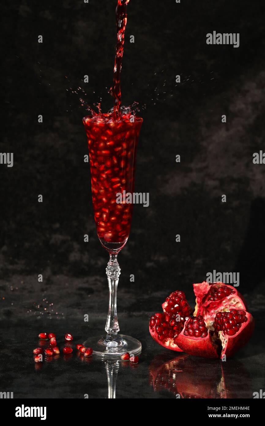 pomegranate wine in the glass on the black background Stock Photo - Alamy