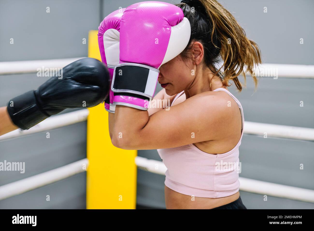 Female boxer protecting herself from her opponent's punches in the ring ...
