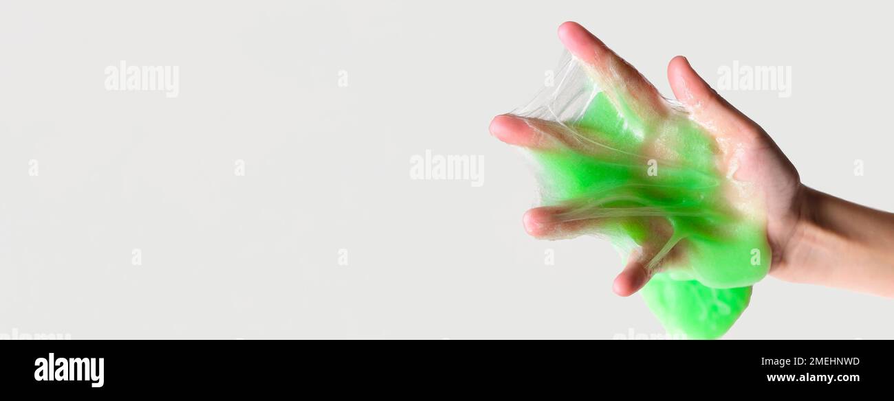 Hand Playing with textured slime on white background. Teen hand holding ...