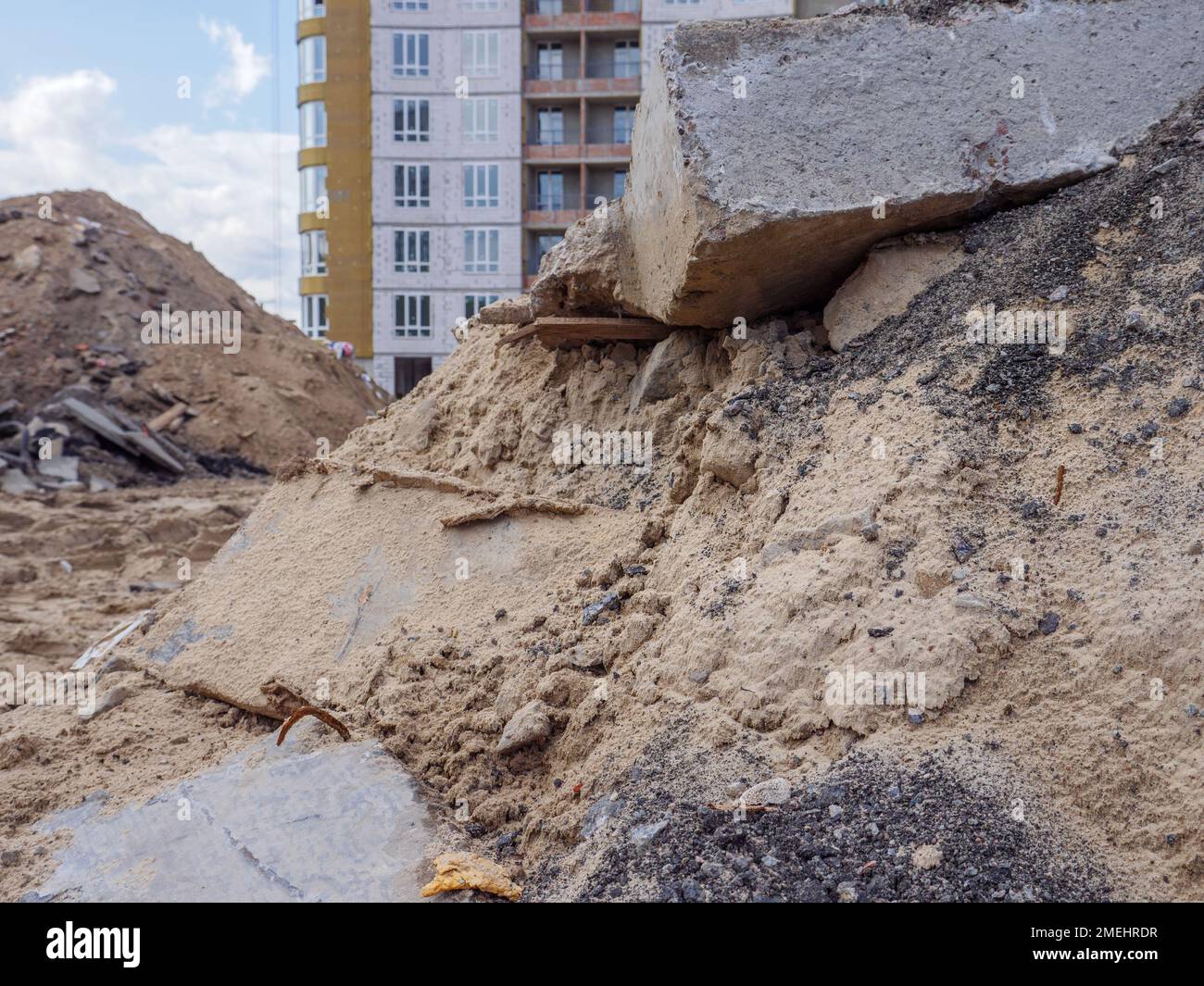 A building site with piles of sand and huge concrete block in the ...