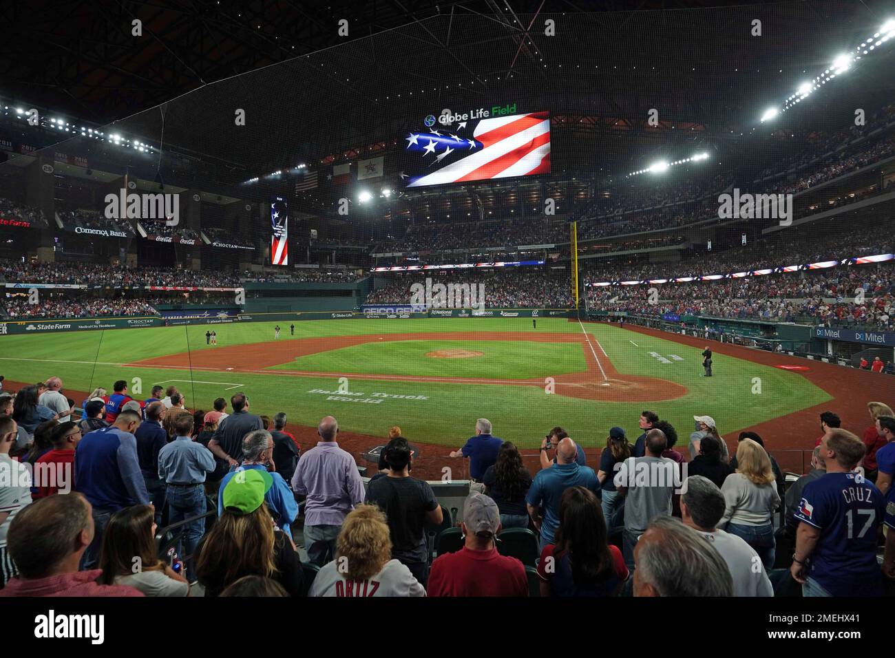 Fans stand for the seventh-inning stretch during a baseball game ...