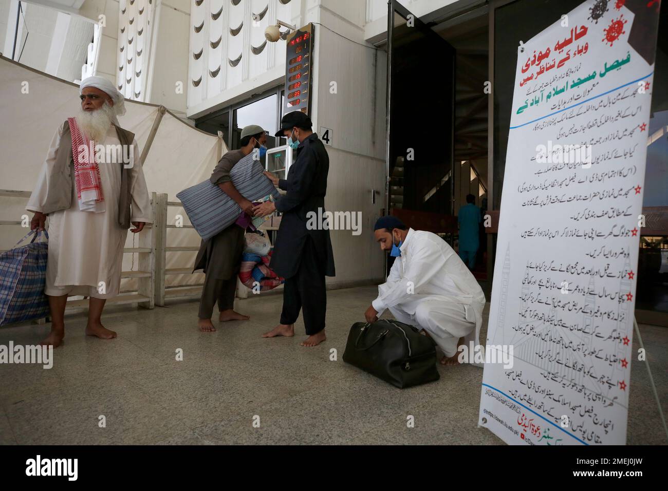 A security officer, center, checks Muslim worshippers arriving to ...
