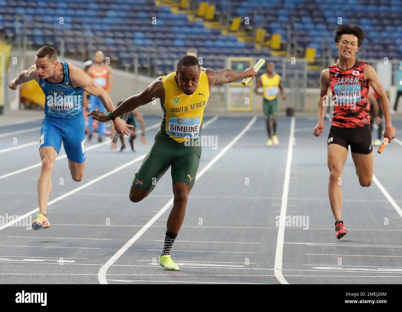 South Africa's Akani Simbine, center, crosses the finish line to win ...