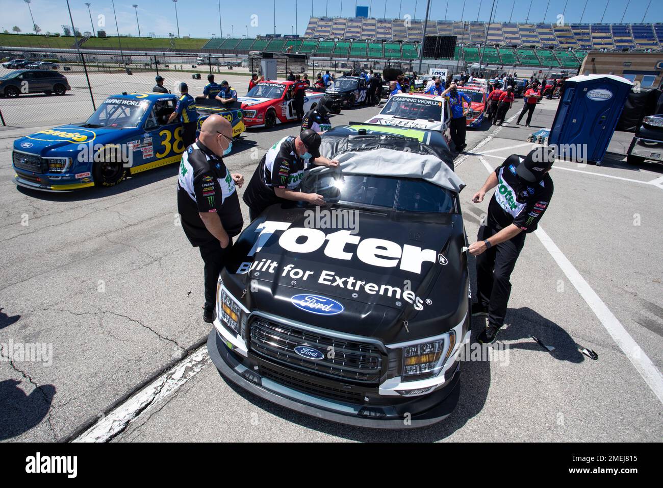 Crew members work on Hailie Deegan's vehicle as they wait in line for ...
