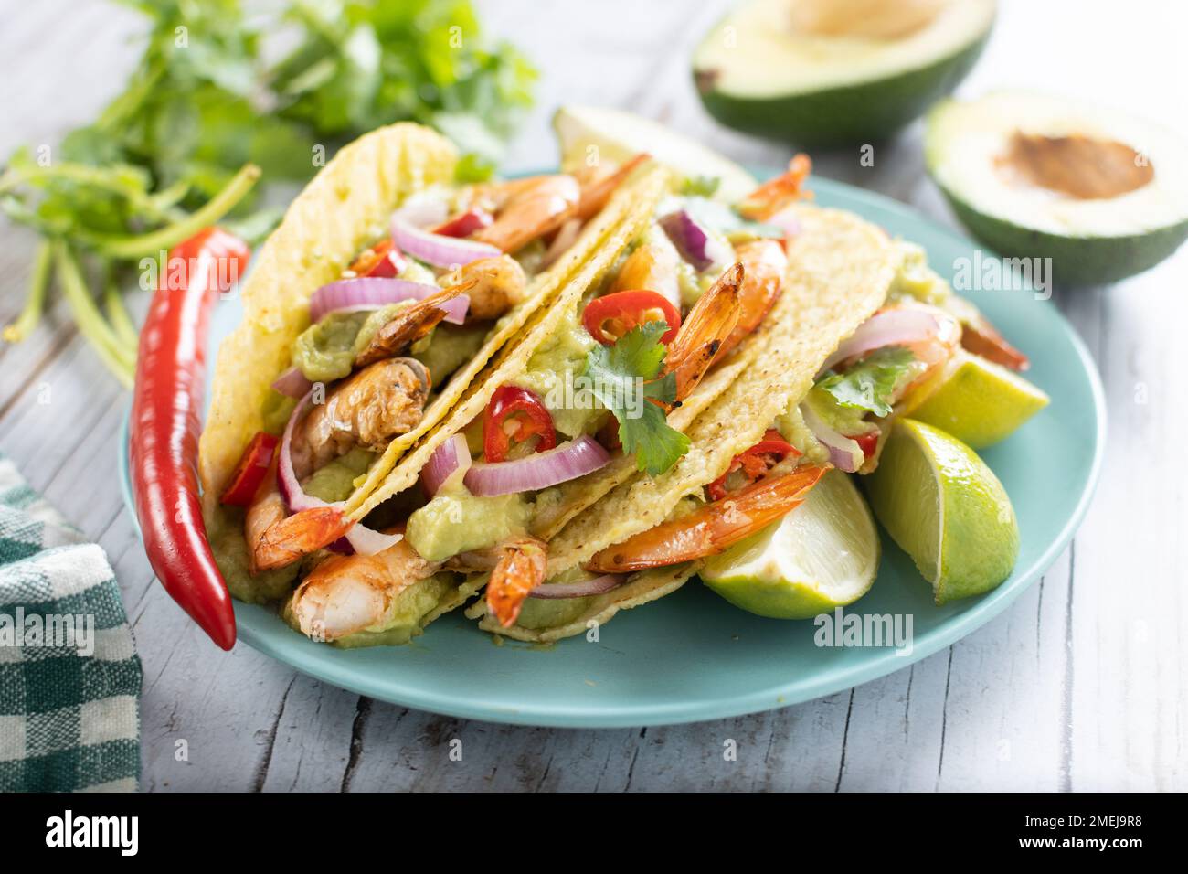 Mexican tacos with shrimp,guacamole and vegetables on wooden table ...