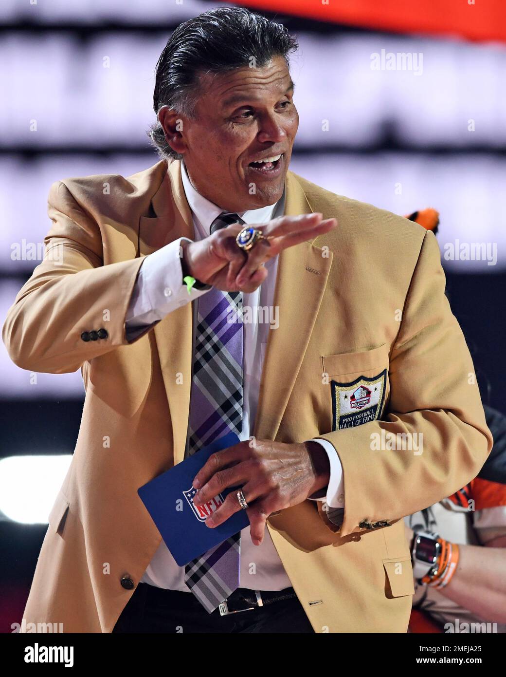 NFL Hall of Famer Anthony Muñoz signals to fans during the third round ...