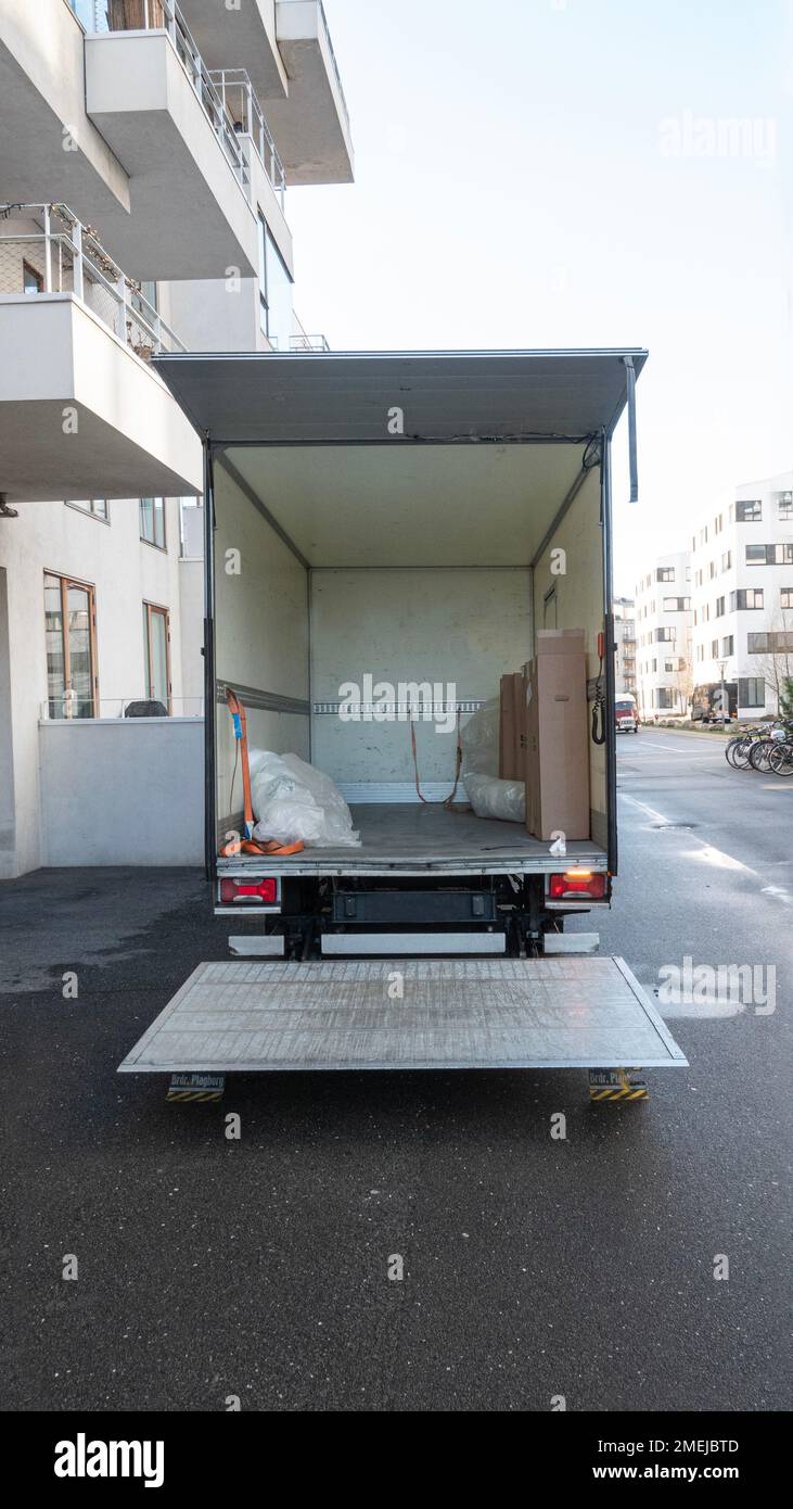 White delivery truck with tailgate open in front of a building. Seen ...