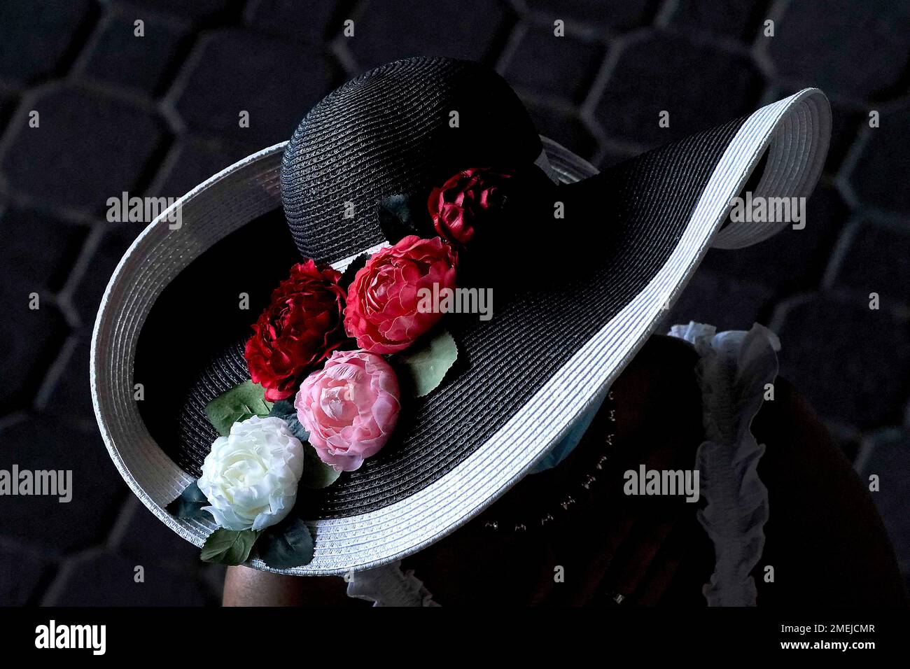 A woman walks to her seat before the 147th running of the Kentucky Oaks ...