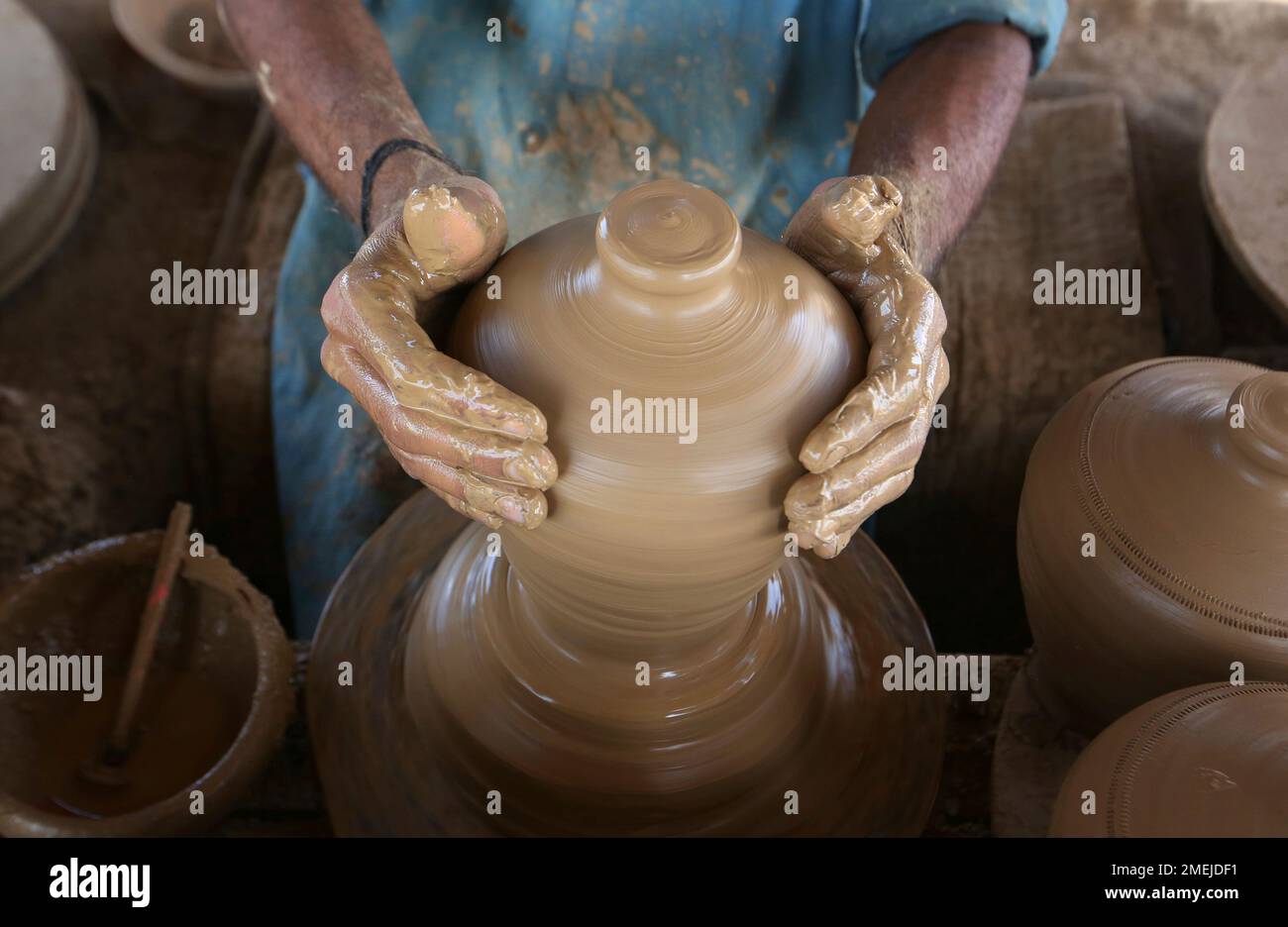 A potter makes a clay pot at his workshop in Karachi, Pakistan, Friday ...