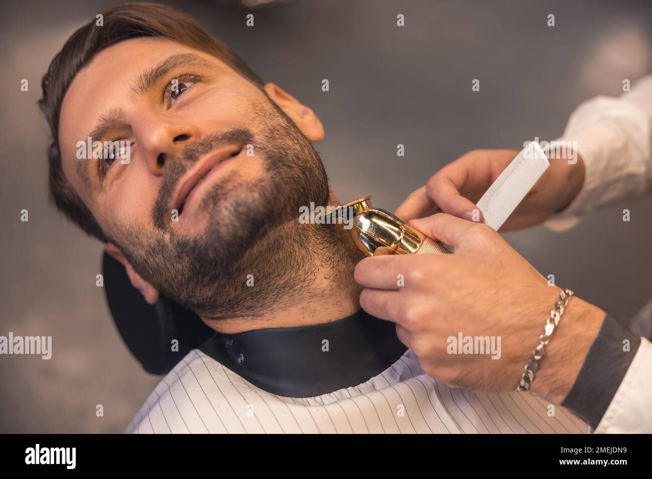 Barber trimming the clients beard Stock Photo - Alamy