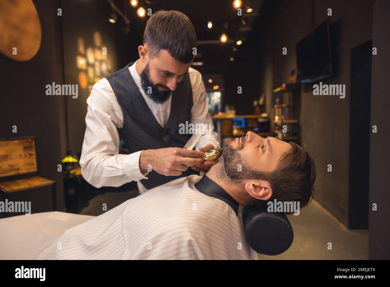 Professional barber carefully trimming the clients beard Stock Photo ...