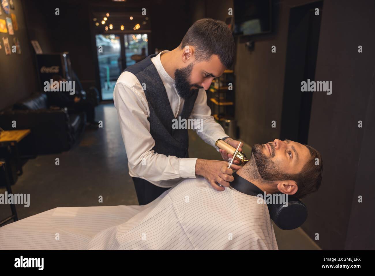 Professional barber carefully trimming the clients beard Stock Photo - Alamy