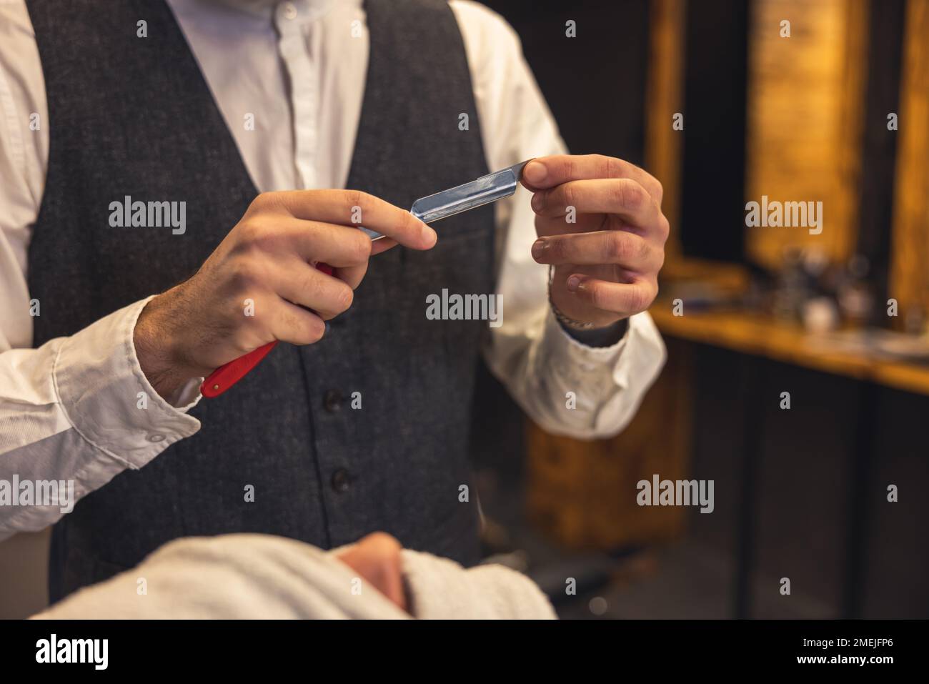 Barber checking the razor sharpness Stock Photo - Alamy