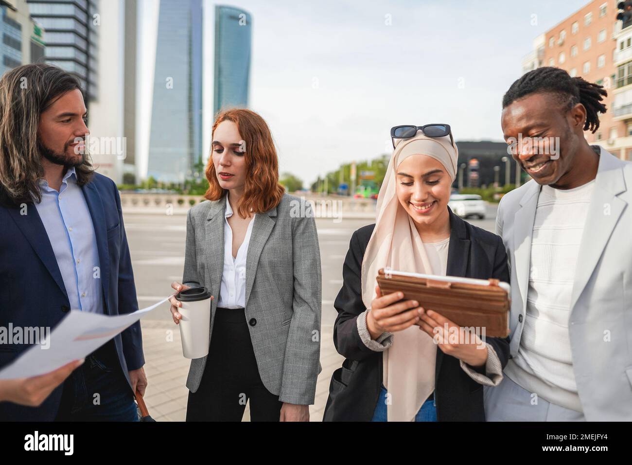 Multiracial business people working outdoor from office building ...