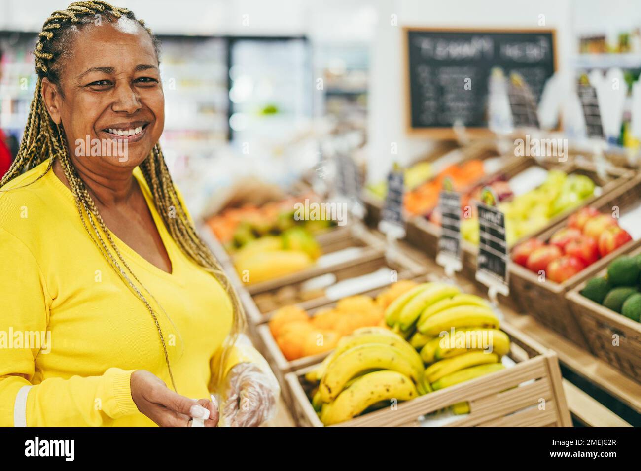 African female customer buying organic food fruits inside eco fresh ...