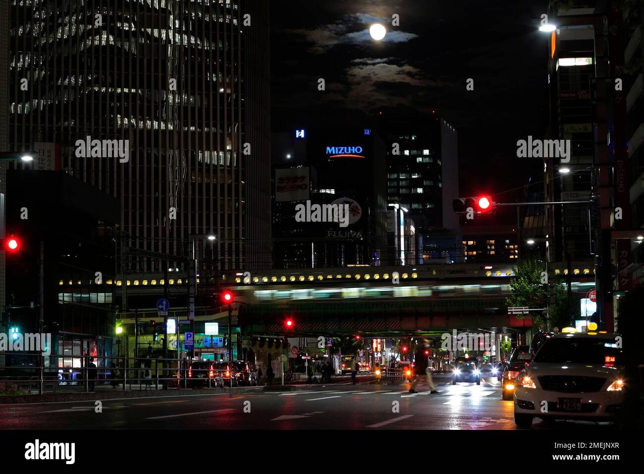 The moon rises as trains pass by Wednesday, April 29, 2021, in Tokyo ...