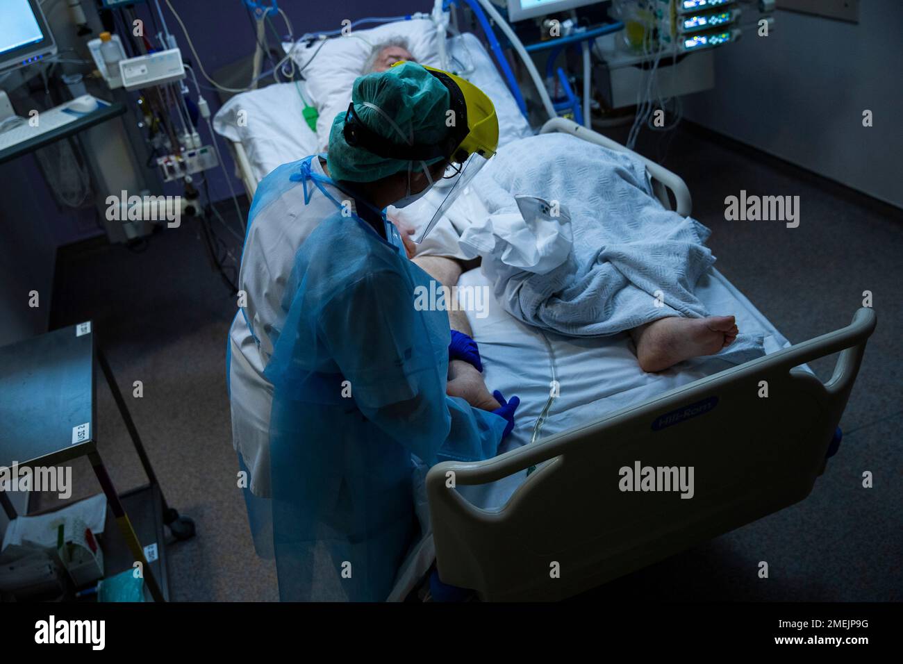 A medical staff member wearing protective equipment tends to a COVID-19 ...