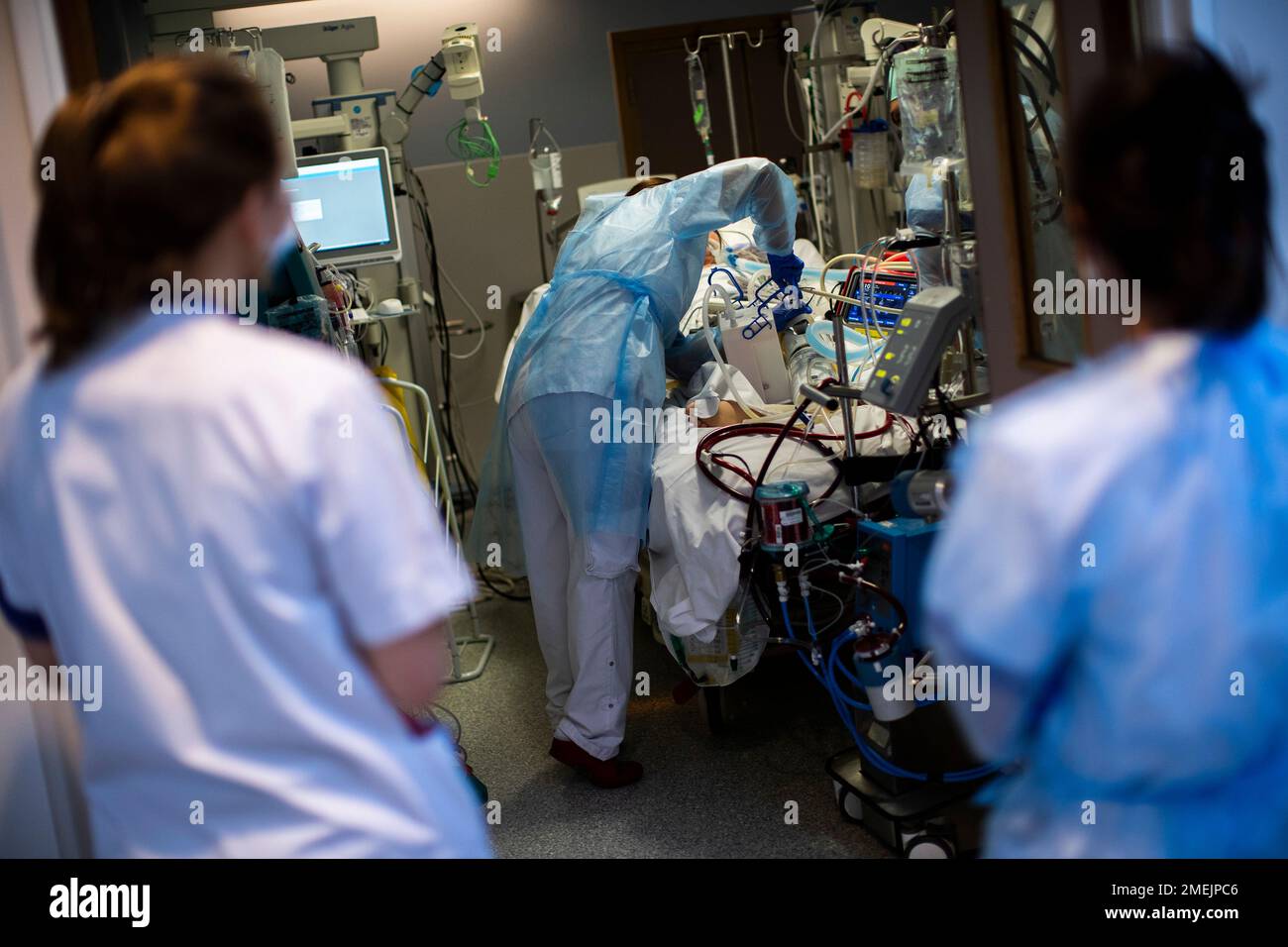 A medical staff member wearing protective equipment tends to a COVID-19 ...