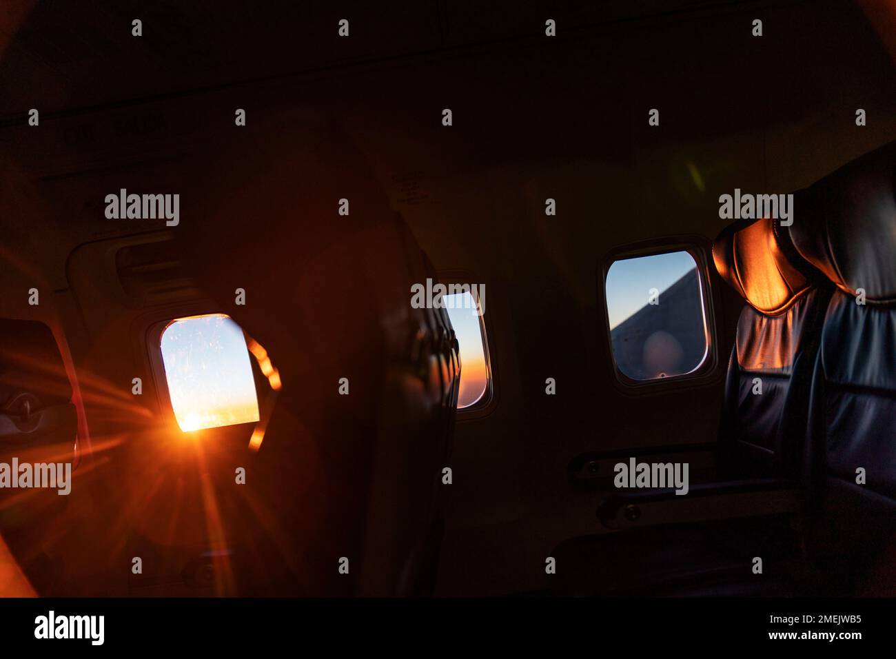 The sun sets outside the window beside an empty seat on a Southwest ...