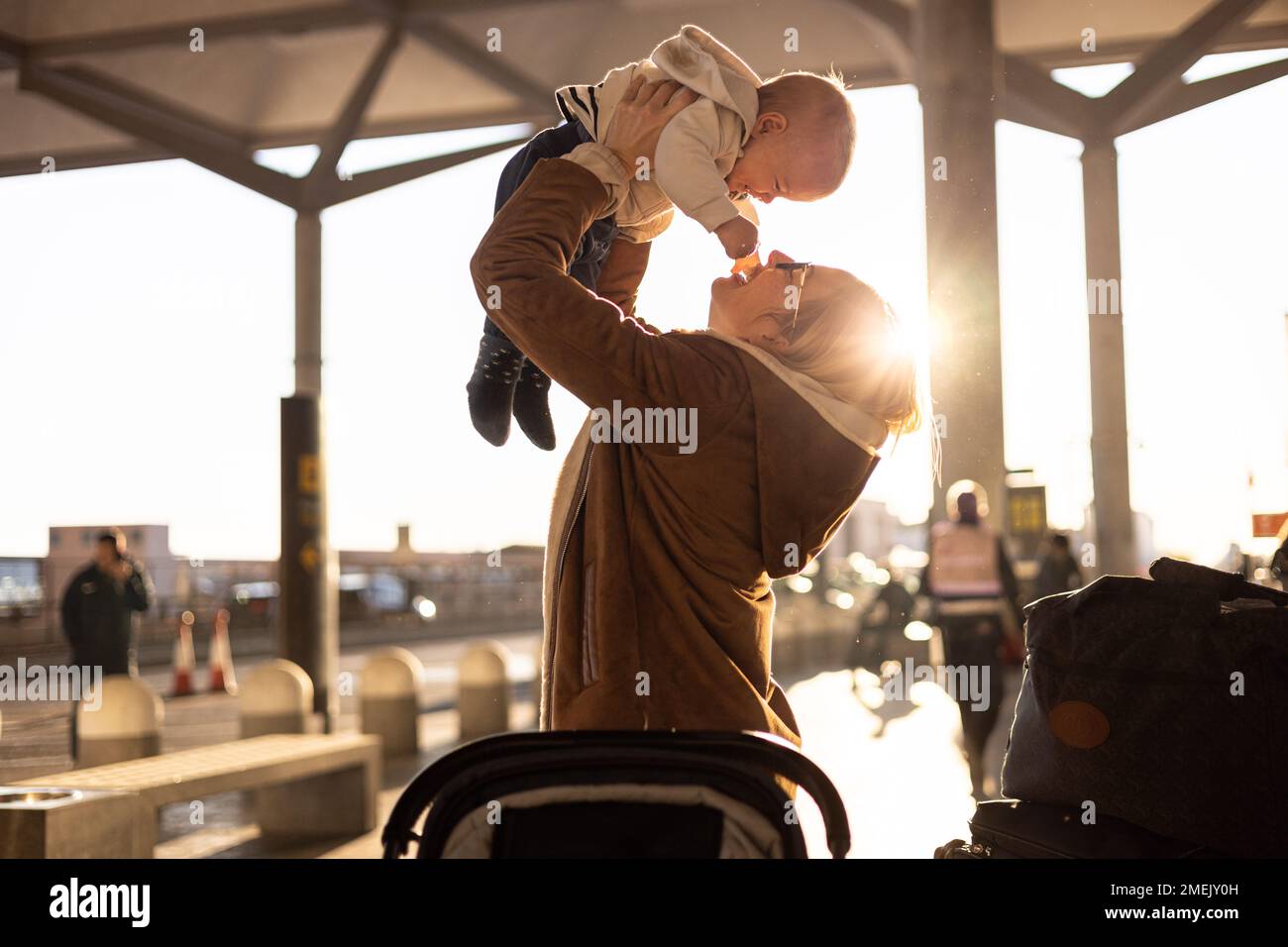 Motherat happily holding and lifting his infant baby boy child in the ...