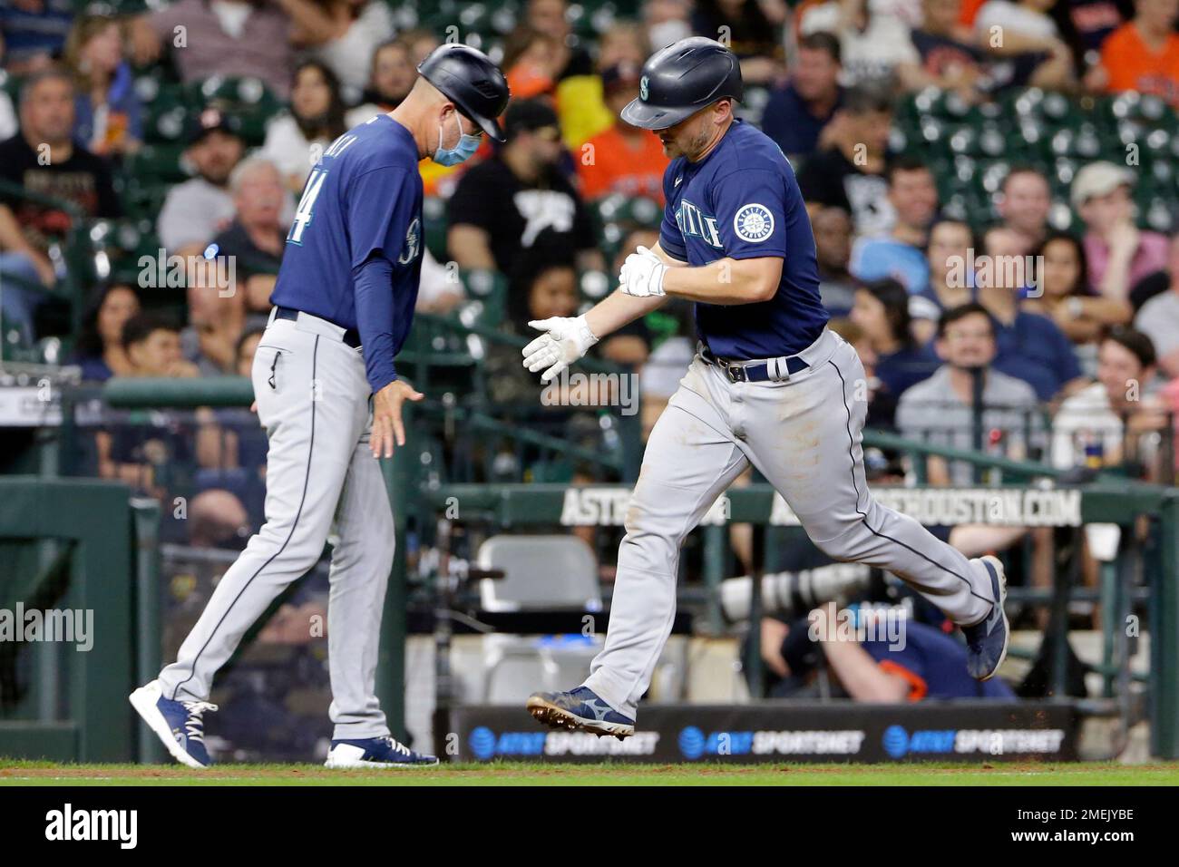 Seattle Mariners third base coach Manny Acta, left, celebrates the home ...