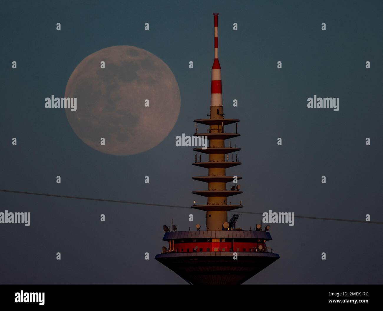 The full moon rises behind the television tower in Frankfurt, Germany ...