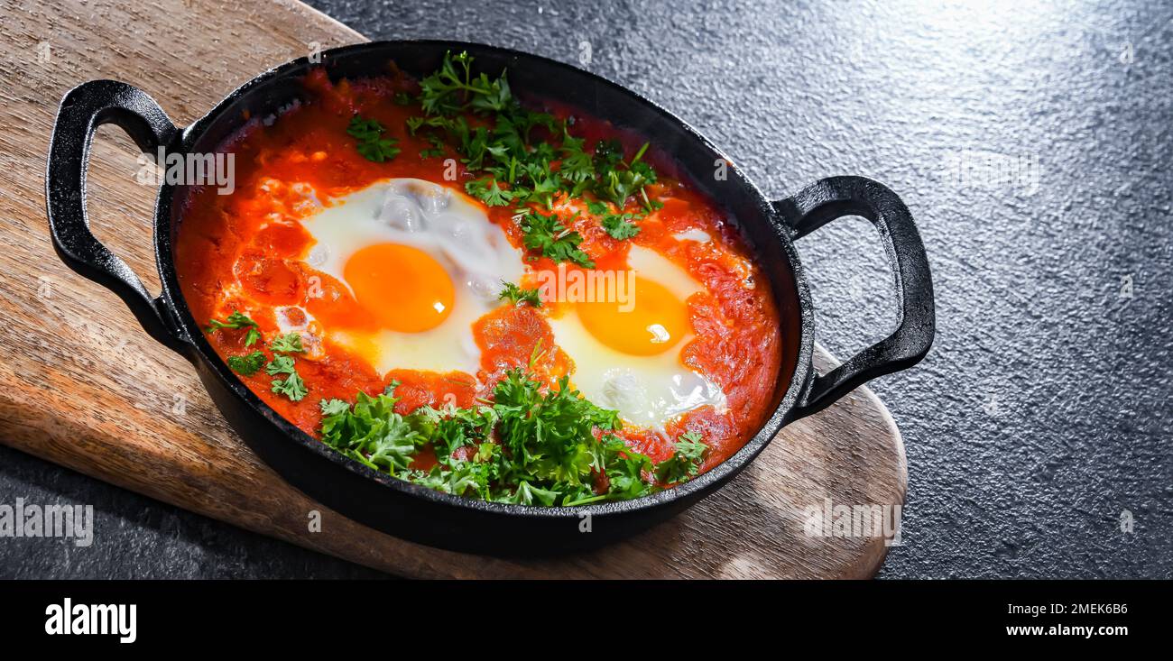 Shakshouka dish in a cast iron pan Stock Photo - Alamy